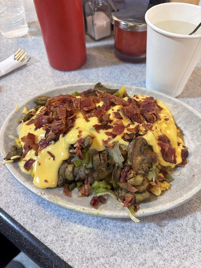 An omelet that's not messing around. Loaded with veggies, draped in cheese, and crowned with bacon&mdash;breakfast royalty on a simple plate.