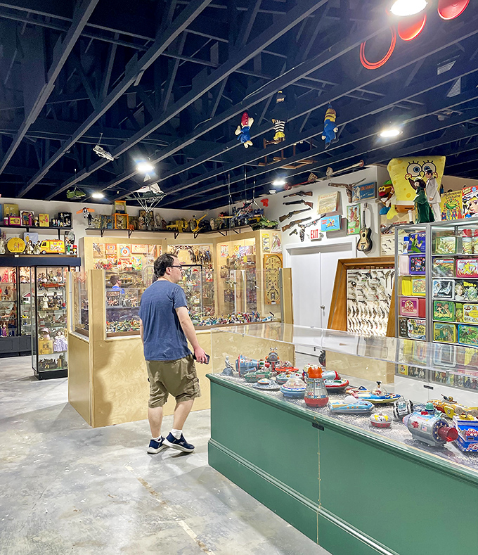 Treasure hunting in progress as a visitor browses display cases. The museum's layout invites wandering between glass-enclosed memories from decades past.