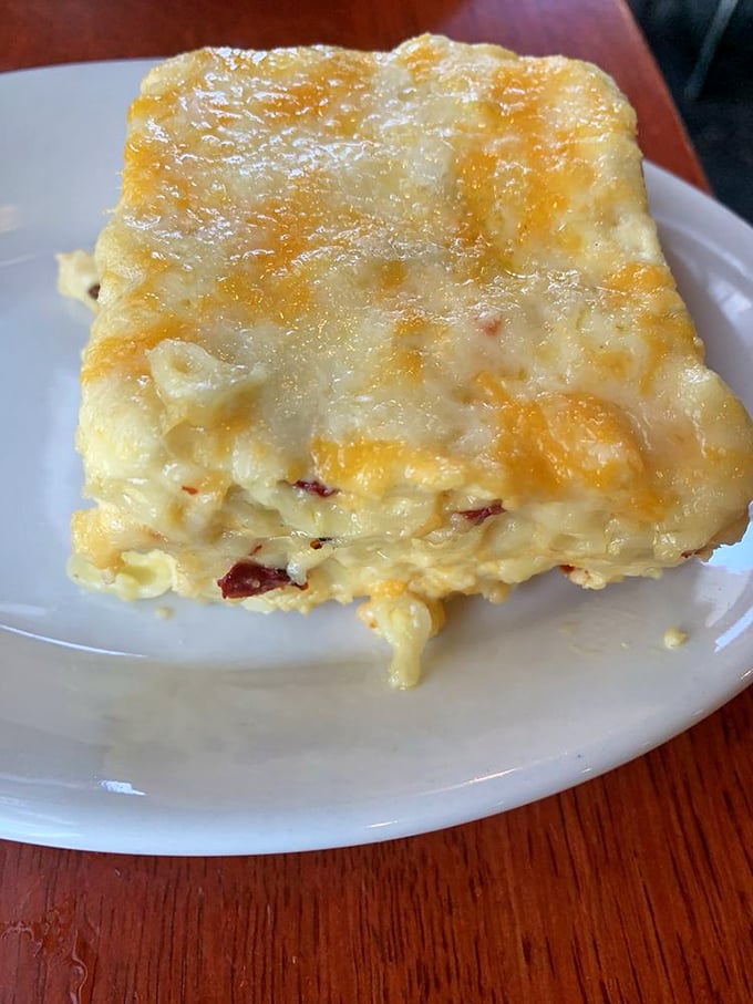 The mac and cheese that launches a thousand debates about whether to share. Creamy, cheesy, with those crispy edges that make you temporarily forget your table manners. 