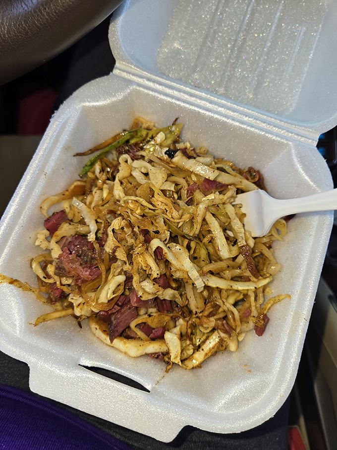 A symphony of textures: smoky pulled pork mingles with crisp, tangy slaw in a takeout container that barely contains all that flavor.