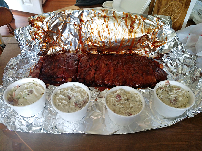A full rack of ribs with sides isn't just a meal&mdash;it's an event. The aluminum foil platter is both practical and a shiny stage for the star attraction.