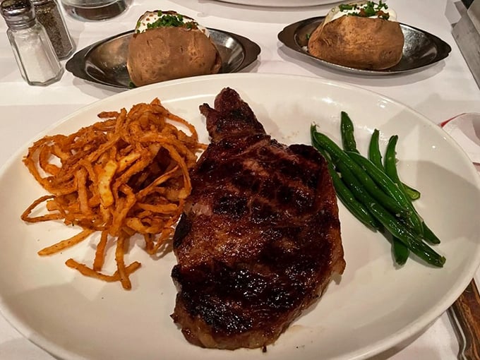 This isn't just a steak; it's a masterpiece with supporting actors: crispy onion strings and green beans. The kind of plate that silences conversation mid-sentence.