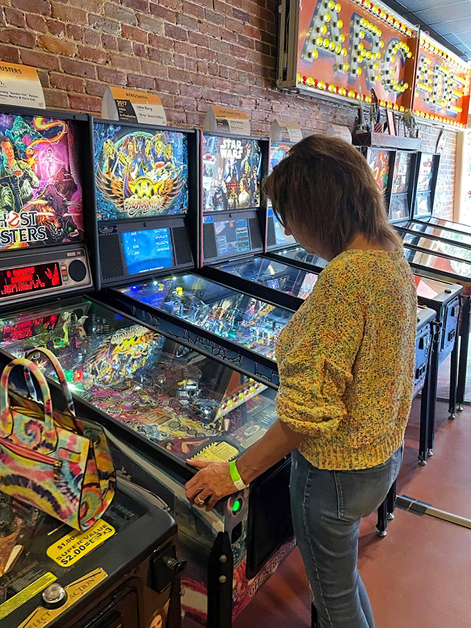Complete concentration on display as a player in a cozy sweater tackles one of the museum's vintage machines. The stance is universal&mdash;slightly hunched, utterly focused.