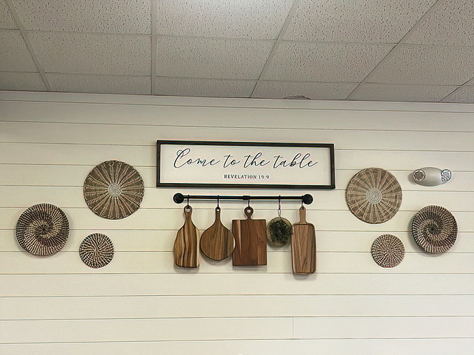 "Come to the table" isn't just a sign&mdash;it's the restaurant's entire philosophy. Those wooden cutting boards aren't decorations; they're heritage hanging on the wall.