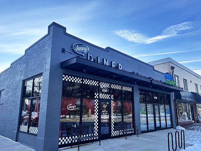 Jenny's Diner's sleek gray exterior with checkered trim offers a modern twist on classic diner charm.