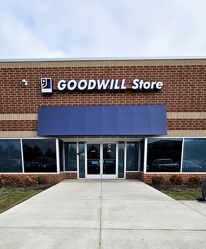 Goodwill's modern storefront offers no hints about the wonderland of treasures hiding inside. That blue awning is the portal to possibility.
