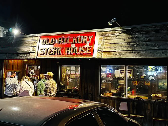 Night transforms this weathered wooden treasure into a beacon for hungry travelers. Those neon lights have guided generations to great steaks.