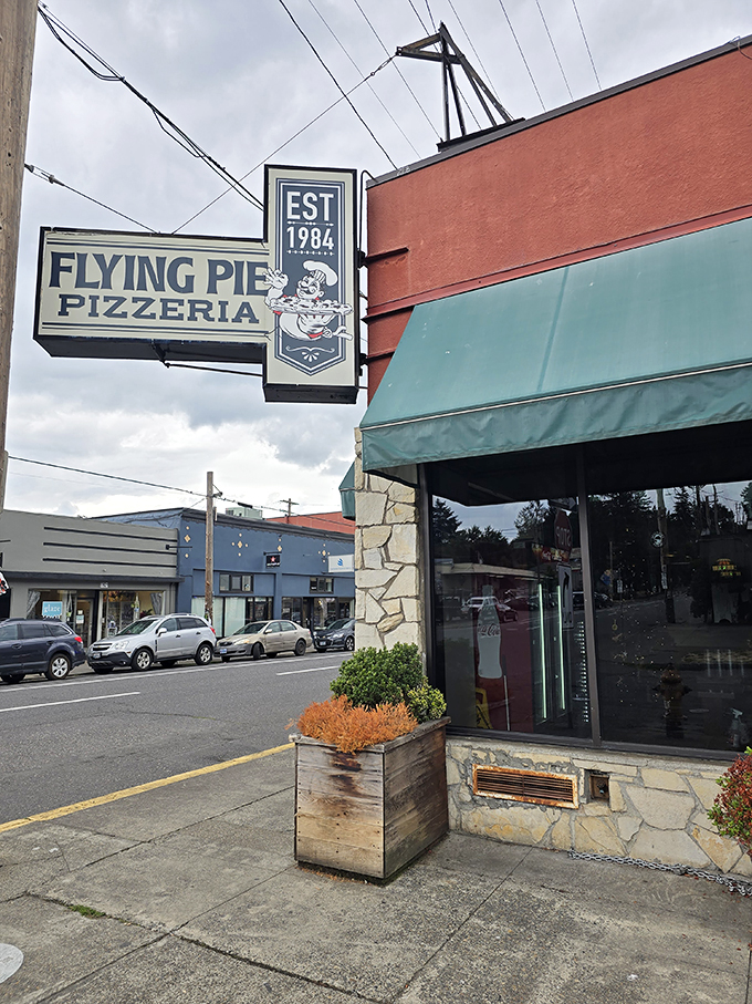 The stone facade and green awning have witnessed decades of Portland's evolution, while the pizza remains gloriously unchanged.