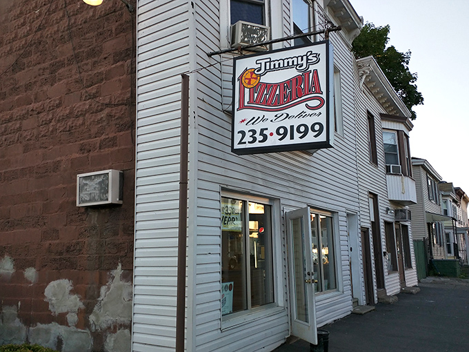 Jimmy's modest storefront at dusk transforms into a beacon for the pizza-hungry souls of Troy.