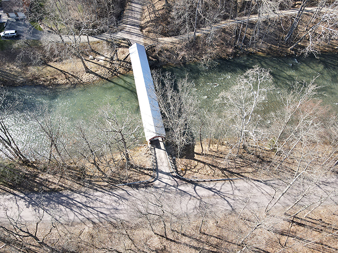From above, the bridge appears as a thin red line connecting not just two banks, but two centuries.