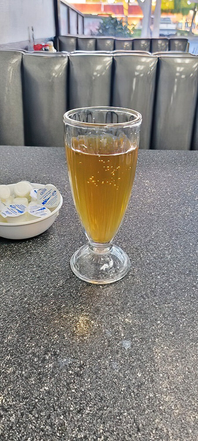 That's not just apple juice&mdash;it's liquid sunshine in a classic fountain glass, ready to wash down whatever breakfast masterpiece you've ordered.