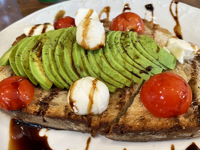 Avocado toast that actually justifies the hype. Perfectly ripe slices, heirloom tomatoes, and a drizzle that ties it all together. 