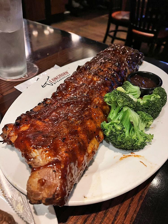 These baby back ribs glisten with sauce like they've been polished, ready to surrender their meat at the gentlest tug. The broccoli is there for moral support.