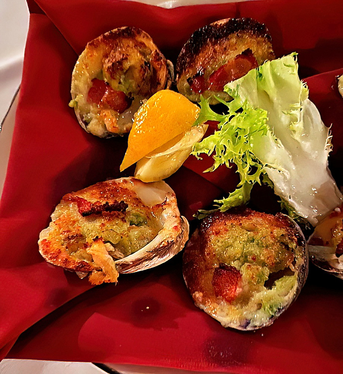 These aren't just baked clams&mdash;they're little boats of briny goodness sailing on a sea of herb butter. The lemon wedge isn't garnish, it's essential equipment.