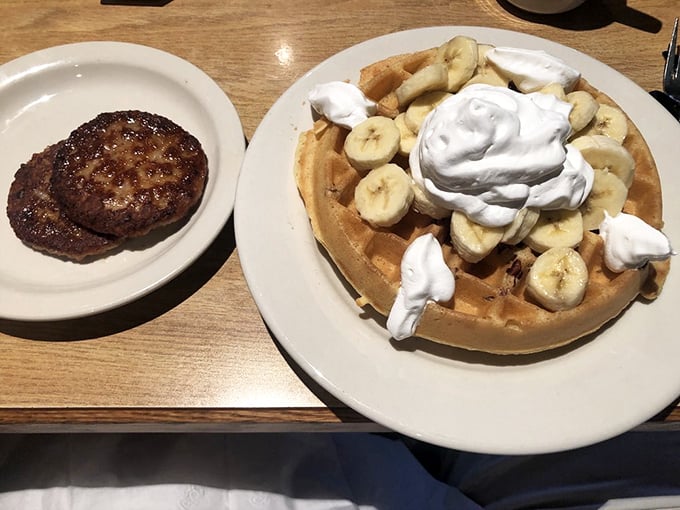 A mountain of whipped cream and sliced bananas on golden waffle terrain &ndash; this isn't breakfast, it's an expedition your taste buds will thank you for.