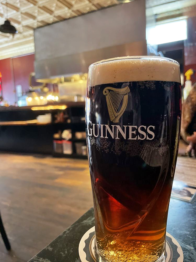 A properly poured Guinness with its perfect tan head—patience rewarded in liquid form while you wait for your fish.