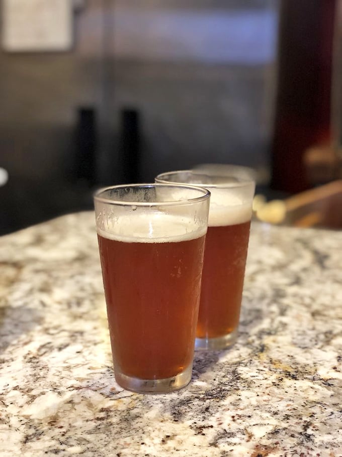 Two glasses of amber beer standing at attention, ready to cut through the richness of smoked meat like a refreshing cavalry charge.