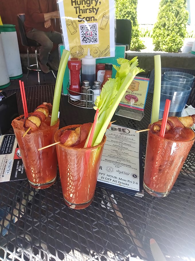 Bloody Marys garnished like a small garden with bacon-wrapped treasures. These aren't just drinks&mdash;they're practically a meal with a kick.