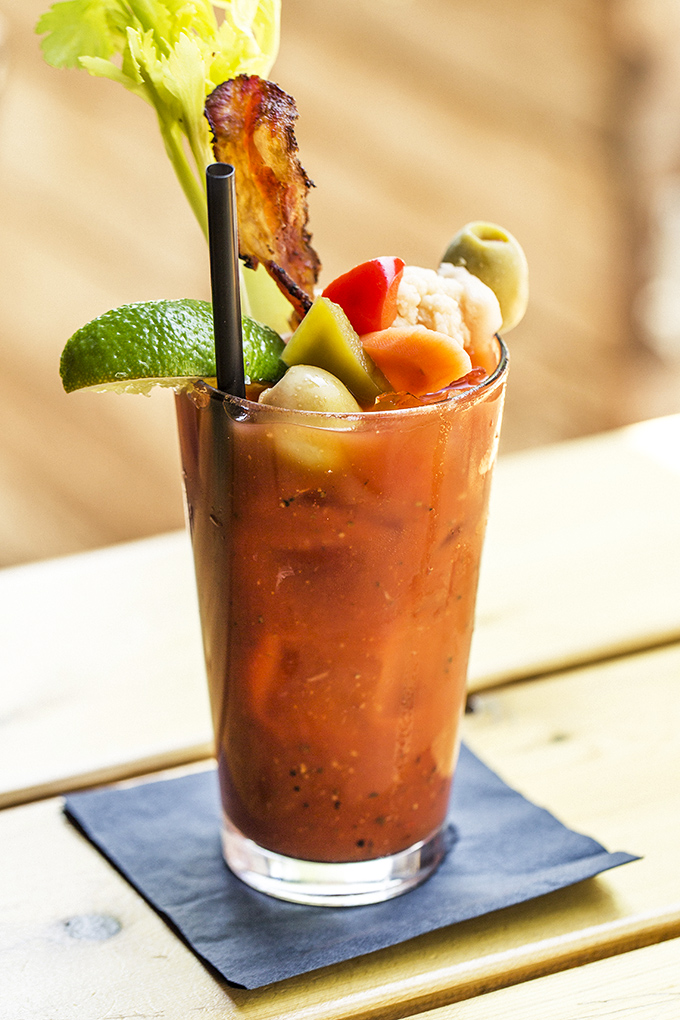 A Bloody Mary that doubles as brunch. That bacon garnish isn't just decoration—it's a mission statement about proper cocktail priorities.