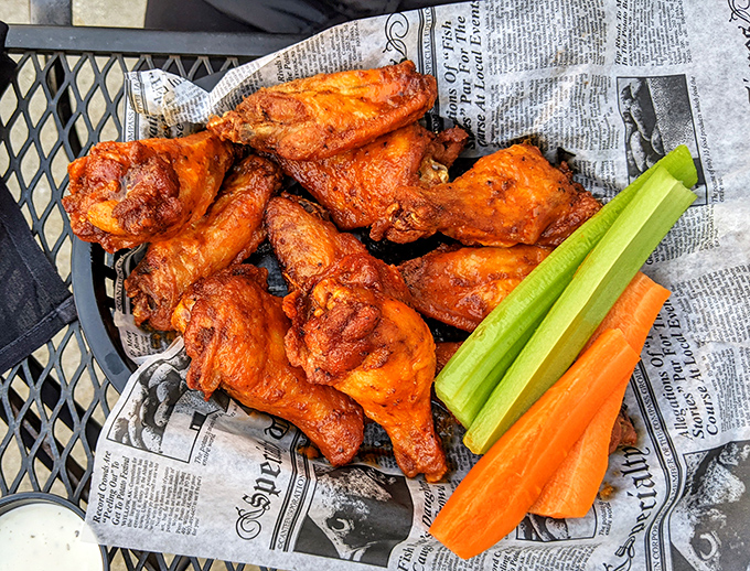 Buffalo wings served on newspaper &ndash; because sometimes the best traditions are the ones that cross borders, bringing American heat to a British setting.