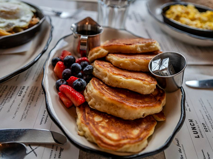 Pancake perfection that would make your grandmother both proud and jealous. The fruit isn't decoration&mdash;it's absolution for what comes next.