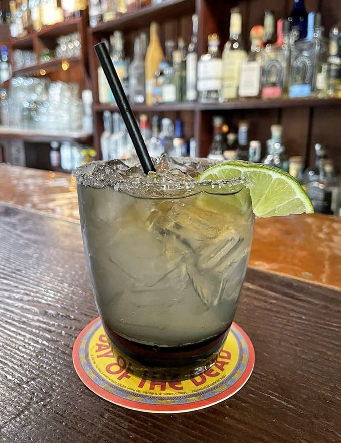 A proper margarita, perched on a wooden bar top&mdash;the lime wedge isn't just garnish, it's an invitation to commence the evening's enjoyment.
