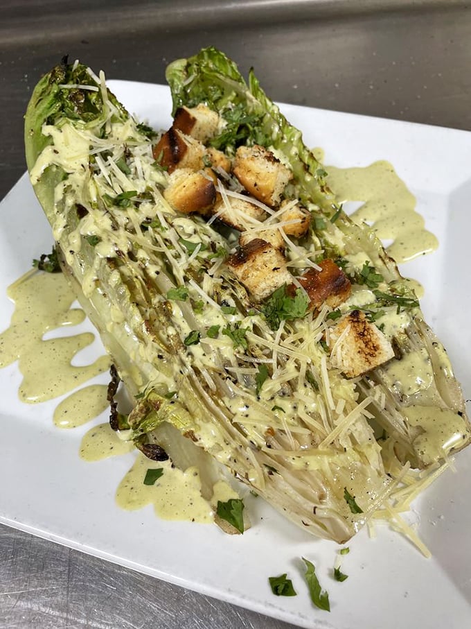 Caesar salad reimagined as art&mdash;romaine hearts grilled to smoky perfection. Parmesan snowfall and croutons that actually deserve the name.