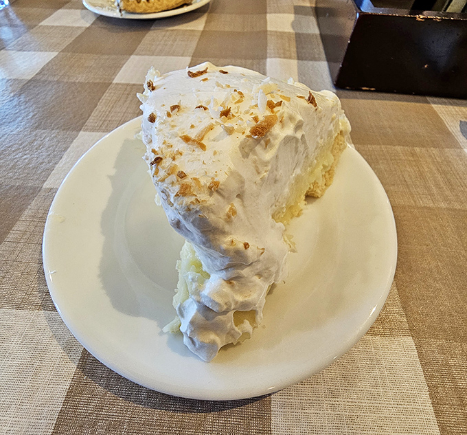 A slice of cloud-like coconut cream pie so tall it practically needs its own zip code. Worth every delicious calorie.
