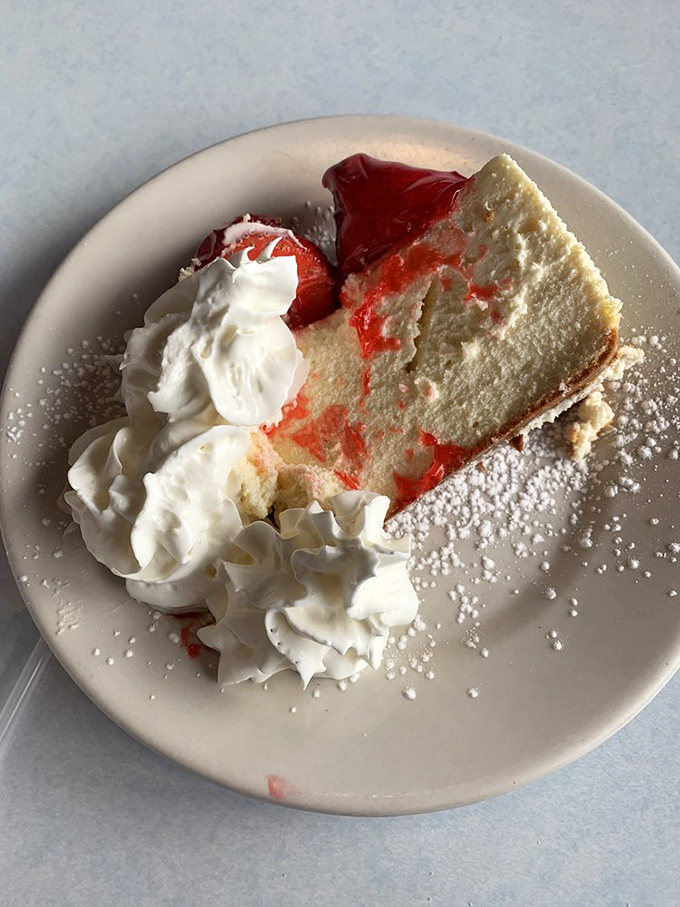 Strawberry cheesecake that makes you consider dessert-first dining as a legitimate lifestyle choice. That whipped cream crown deserves its own royal title. 