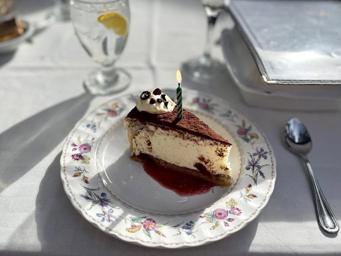 A slice of cheesecake with a birthday candle&mdash;because any day you eat this well deserves celebration.