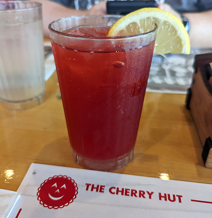 That ruby-red Cherry Ade isn't just a beverage—it's summer in a glass, complete with a lemon slice that's basically just showing off at this point.