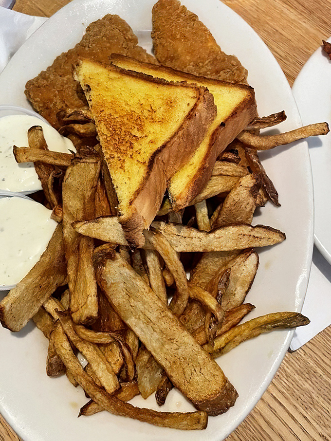 Golden fries and toast flank these chicken strips like loyal sidekicks, ready to support the main character in your hunger story.