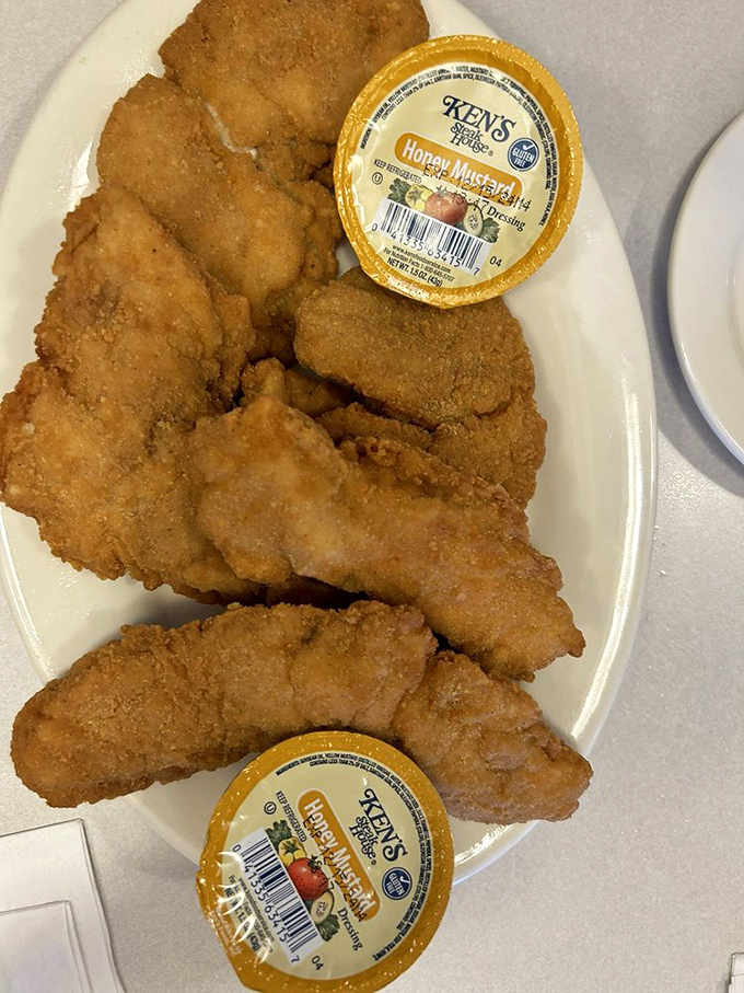 Golden-fried chicken tenders that crunch louder than your dad's favorite potato chips, served with honey mustard that's worth the sticky fingers.
