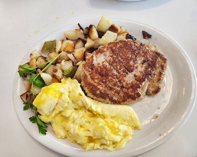Two sunny-side-up eggs keeping company with crispy hash browns and sausage&mdash;the breakfast equivalent of a perfect day.
