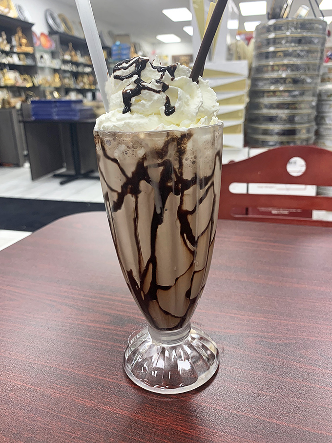 This isn't just a milkshake&mdash;it's a skyscraper of indulgence with chocolate drizzles forming the architectural support beams of deliciousness.