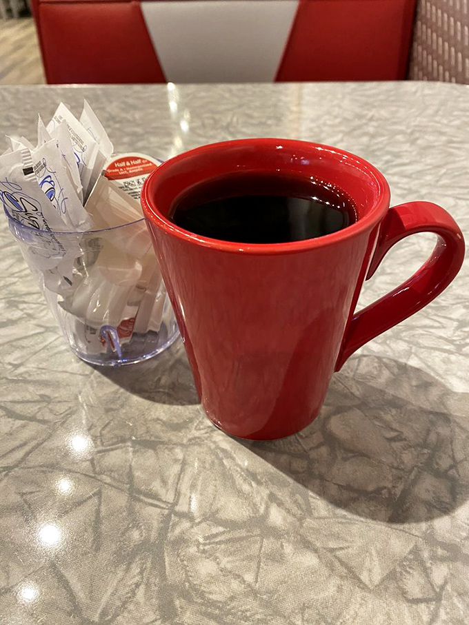 The classic red coffee mug &ndash; holding the life-giving elixir that transforms morning zombies into functioning humans since forever.