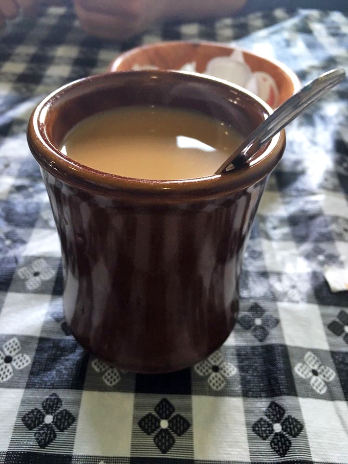 Coffee served in a sturdy brown mug—no fancy latte art needed when the brew itself is this honest and satisfying.
