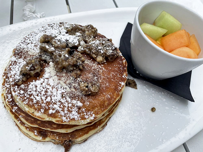 These pancakes don't just arrive at your table—they make an entrance. Stacked high with crumble topping and powdered sugar, they're breakfast's answer to formal wear.