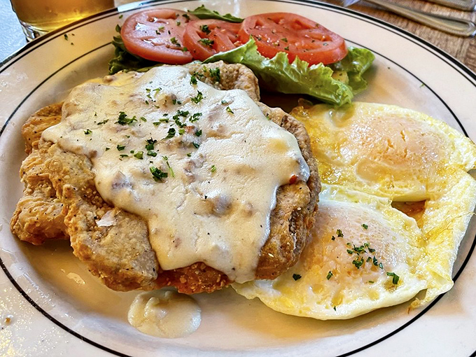 Country fried steak smothered in gravy alongside sunny-side-up eggs. Comfort food that hugs your soul while simultaneously plotting against your arteries.