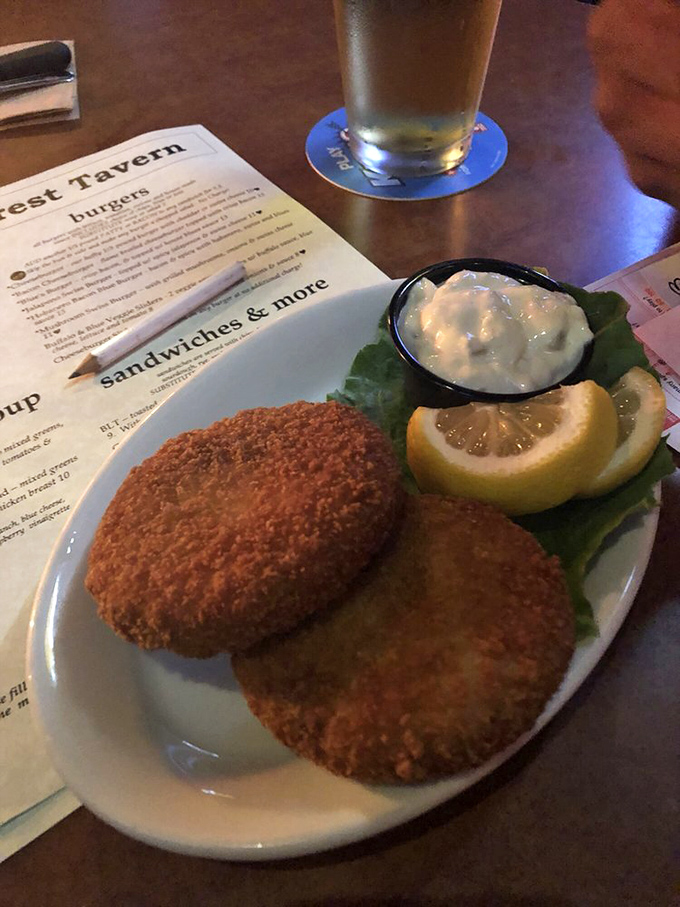 Golden-brown crab cakes with a side of tartar sauce &ndash; proof that tavern food can transcend the ordinary when done with care.