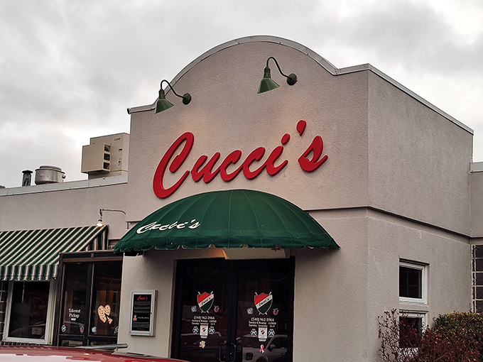 Cucci's Pizza beckons with its classic signage &ndash; the kind of local spot where they remember your order before you've finished saying hello.