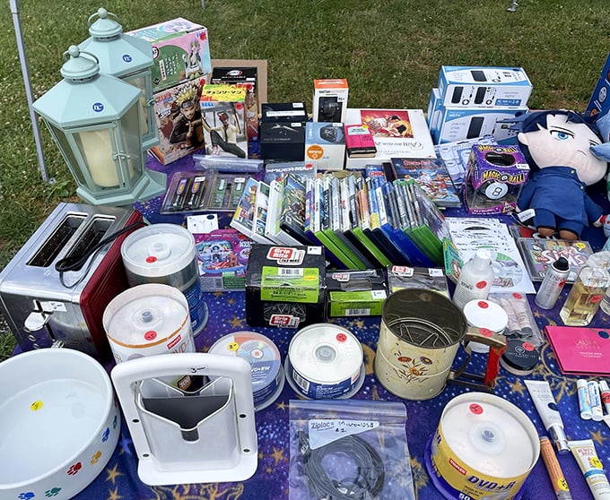 The modern yard sale symphony&mdash;DVDs, kitchen gadgets, and mysterious electronic devices all hoping for a second act in someone else's home.