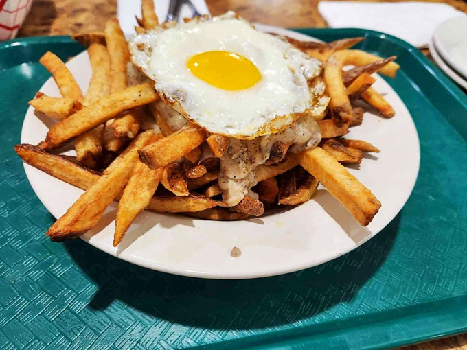 Fries supporting the weight of expectations&mdash;and a perfectly fried egg. This mountain of potato goodness is what comfort food aspiration looks like.