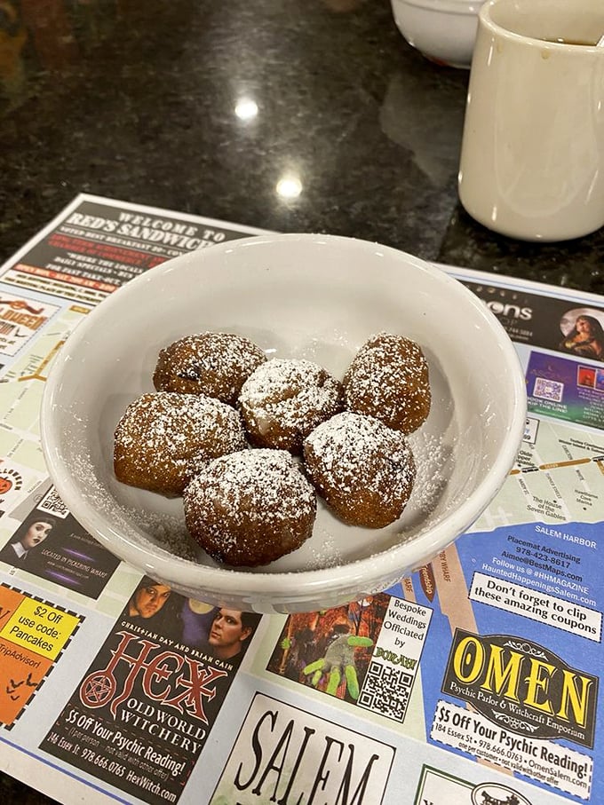 These powdered sugar-dusted donut holes aren't just dessert, they're little spheres of happiness that make waiting for your main course a pleasure.