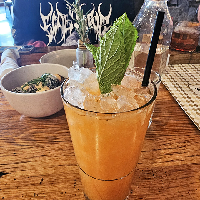 Cocktail artistry in full effect. That fresh mint leaf isn't just garnish&mdash;it's an aromatic invitation to the refreshing experience below the ice.