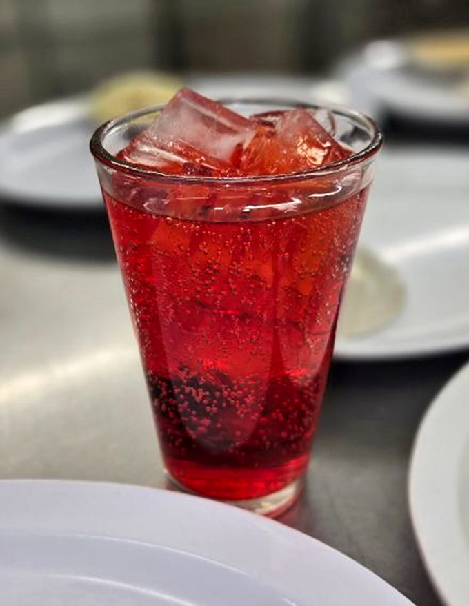That ruby-red beverage isn't just a drink—it's the perfect sweet counterpoint to cut through all that savory goodness.