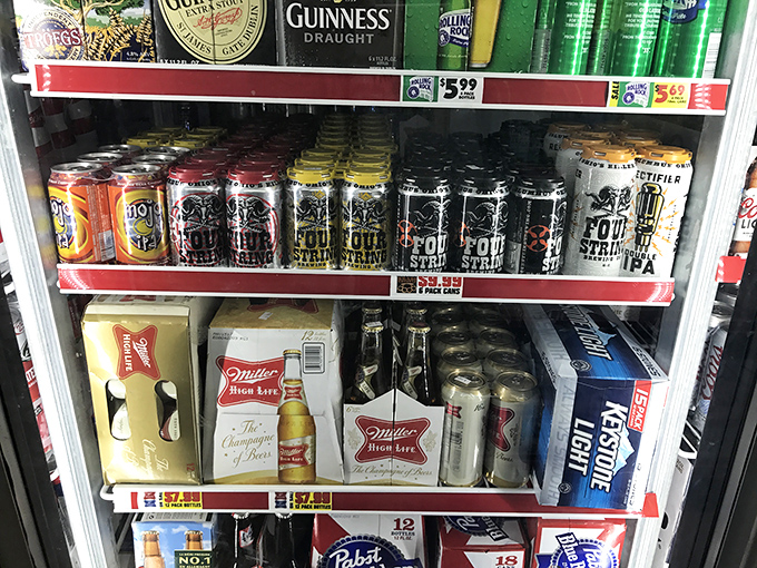 The beer cooler—a chilled oasis of liquid refreshment where local brews mingle with national favorites, ready to wash down that perfect pizza slice.