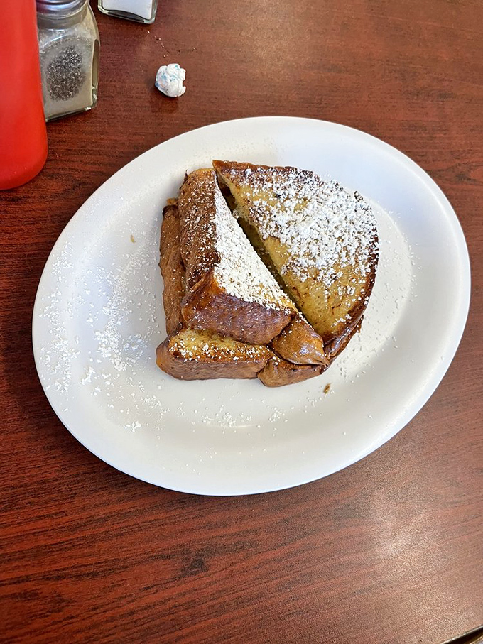 French toast that's achieved the impossible trifecta: custardy center, caramelized exterior, and just enough powdered sugar to make you feel fancy.