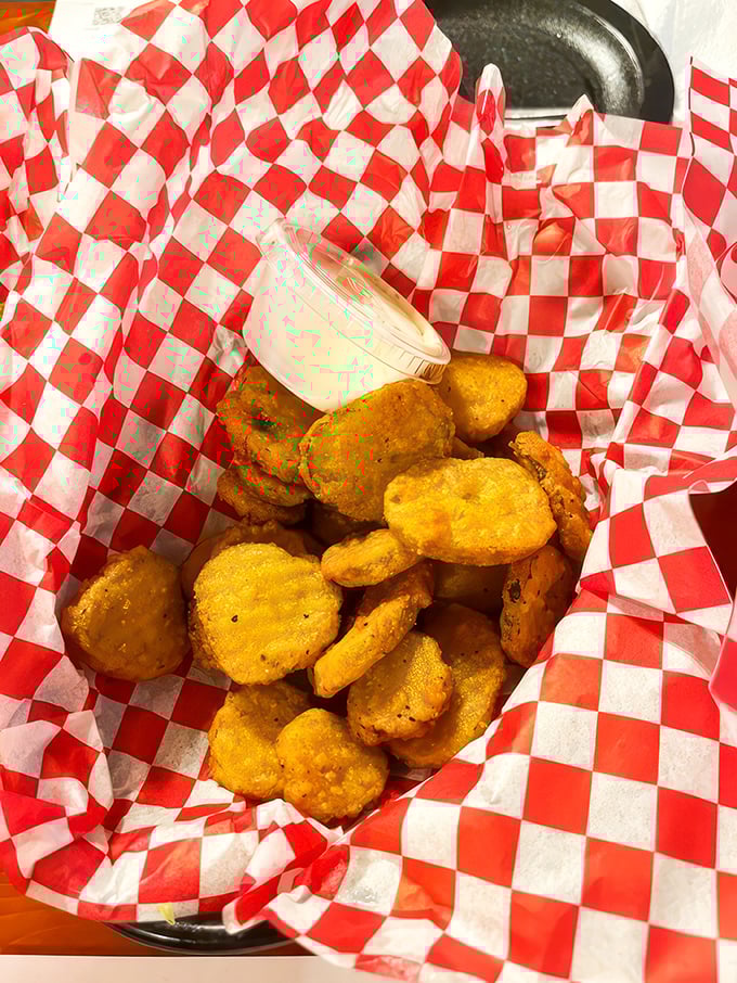 Fried pickle chips served in checkered paper &ndash; the universal signal for "something delicious this way comes." Tangy, crunchy perfection awaits.