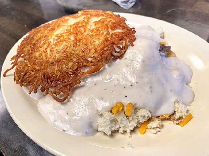 A symphony of textures: crispy hash browns meet creamy gravy while a biscuit waits patiently underneath. This is breakfast architecture at its finest.